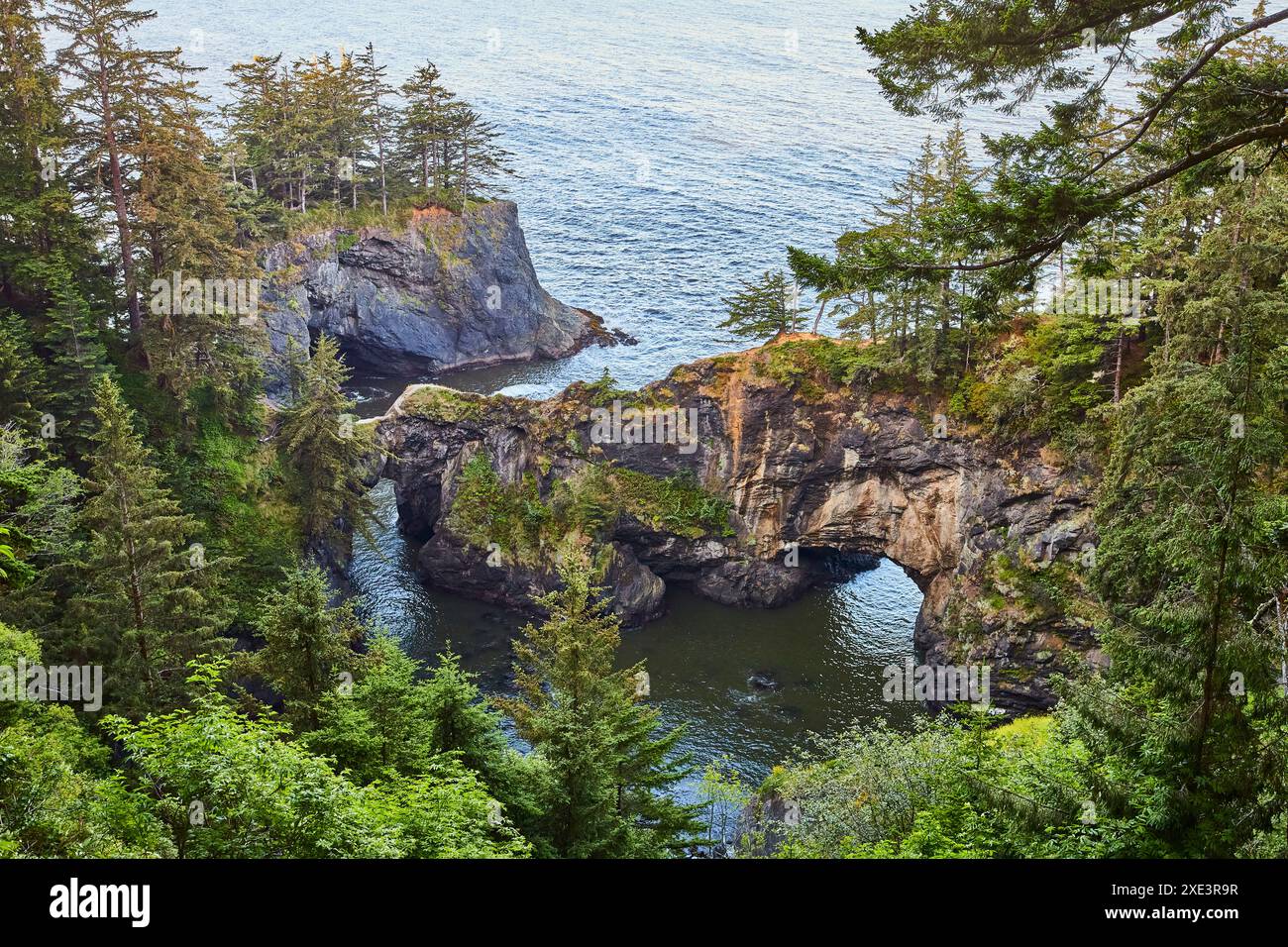 Aerial Fly Through Natural Rock Arch with Ocean View and Evergreen ...