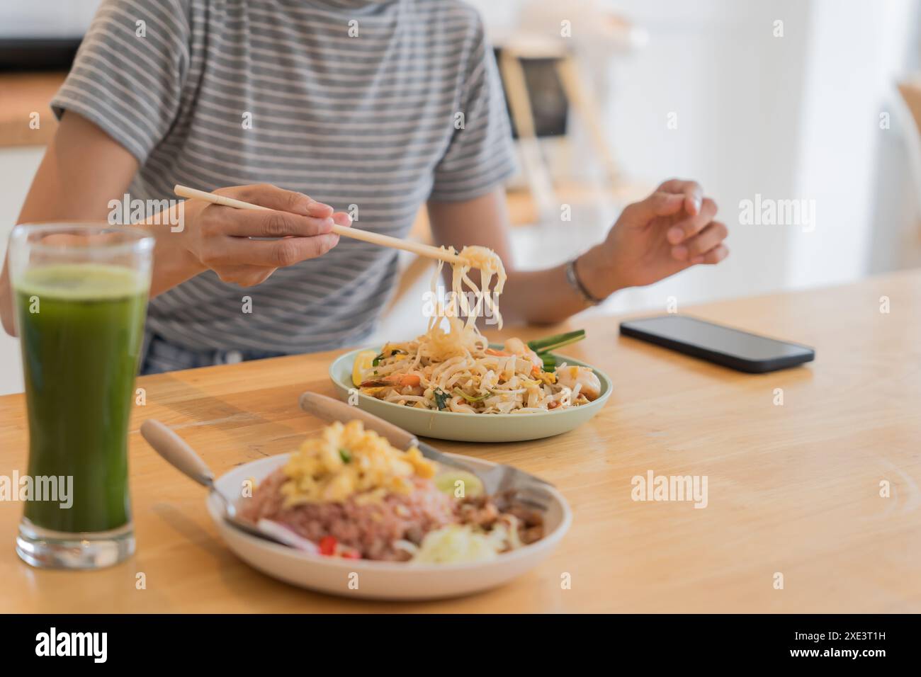 Asian Girl Â eating Thai food in kitchen counter Home delivery food ...
