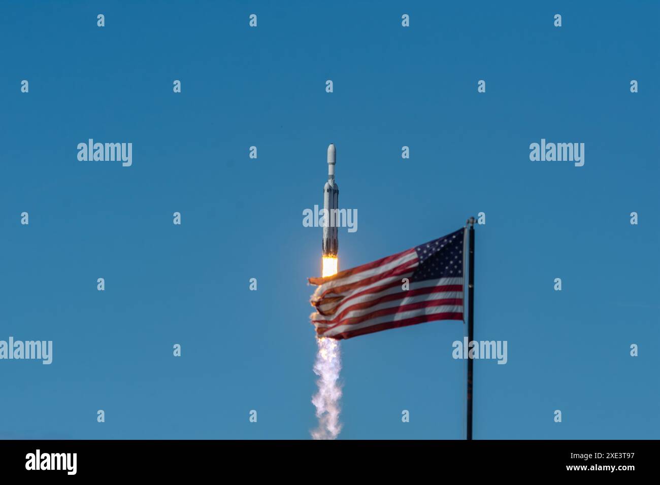 June 25, 2024: A SpaceX Falcon Heavy passes the American Flag located ...
