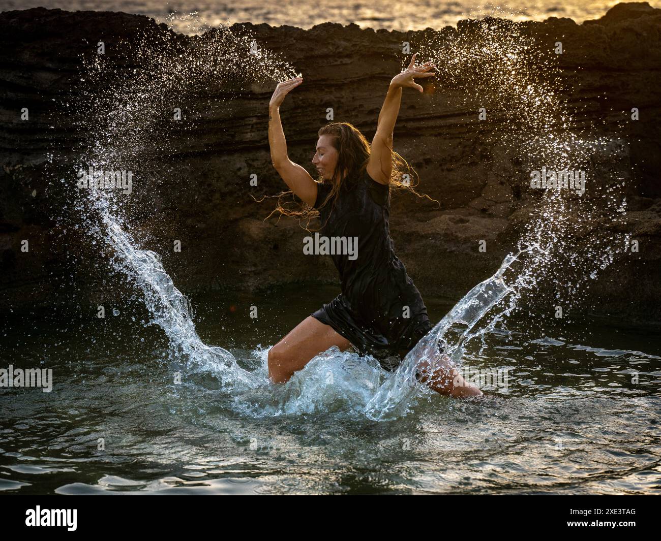 Middle-aged woman dancing and throwing water in the air Stock Photo - Alamy