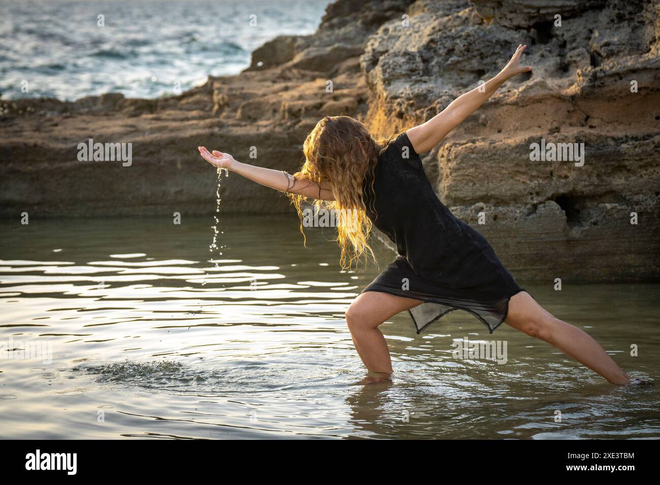 Middle-aged woman dancing and throwing water in the air Stock Photo - Alamy