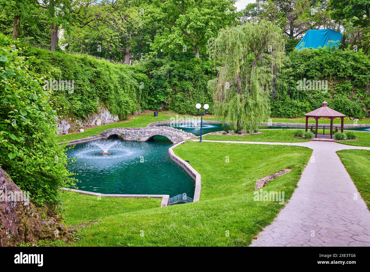 Serene Stone Bridge and Pond with Fountains in Huntington Sunken ...
