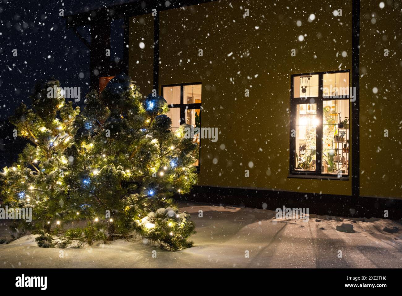 Cozy festive window of the house outside with the warm light of fairy ...