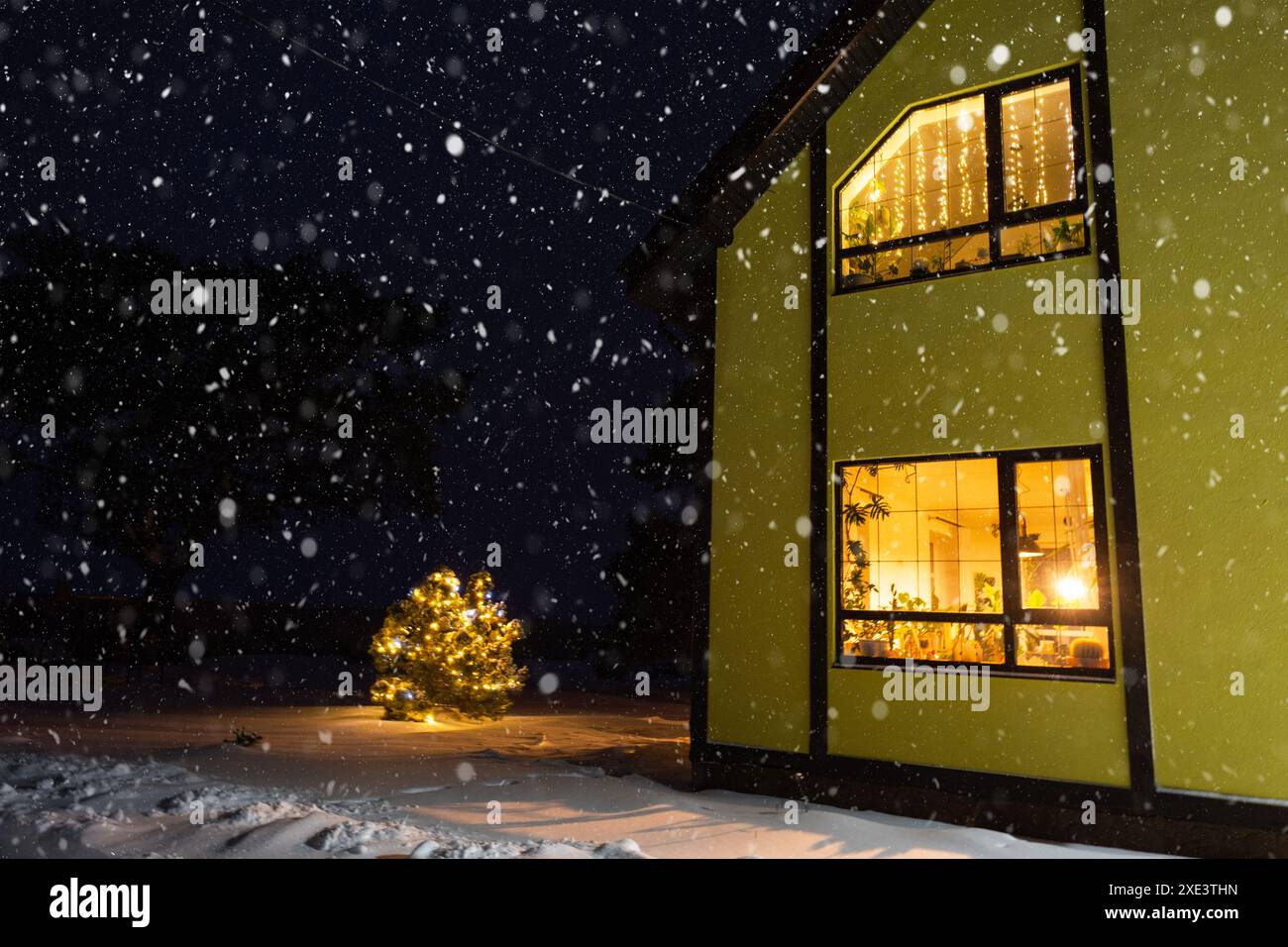 Cozy festive window of the house outside with the warm light of fairy ...
