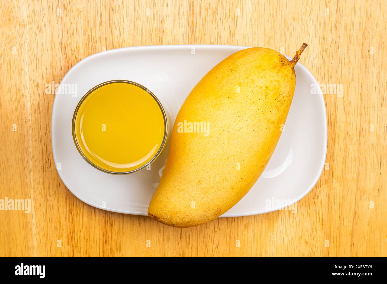 Top view or flat lay of fresh sweet mango juice and ripe yellow mango ...