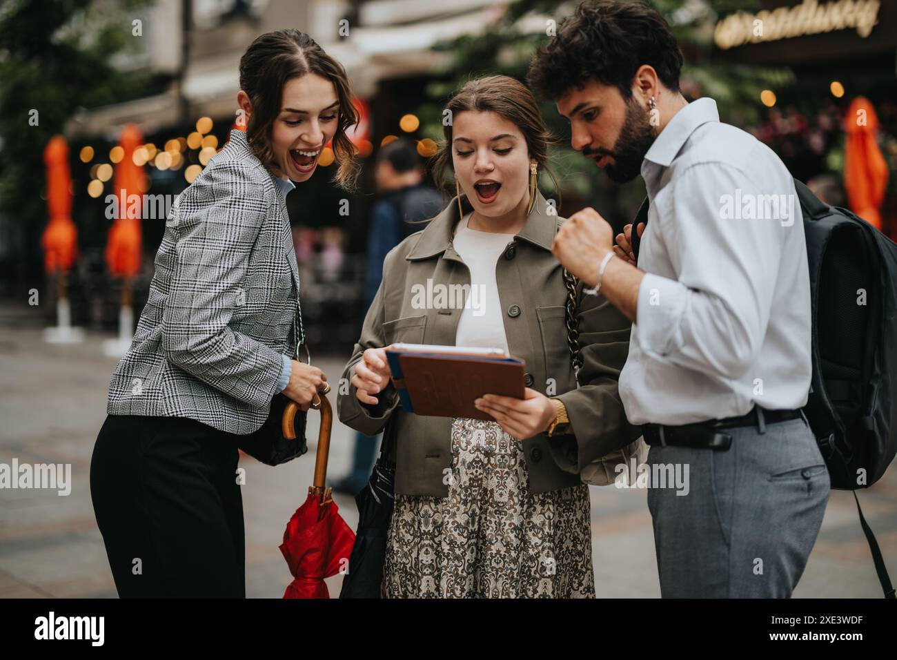 Excited businesspeople having an outdoor meeting while looking at a ...
