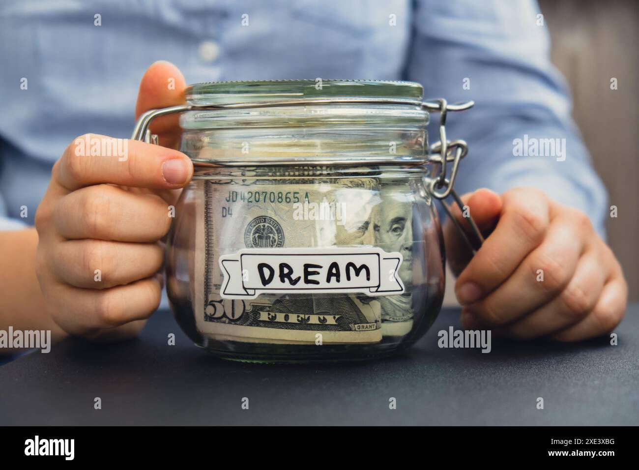 Female hands holding Glass jar full of American currency dollars cash ...