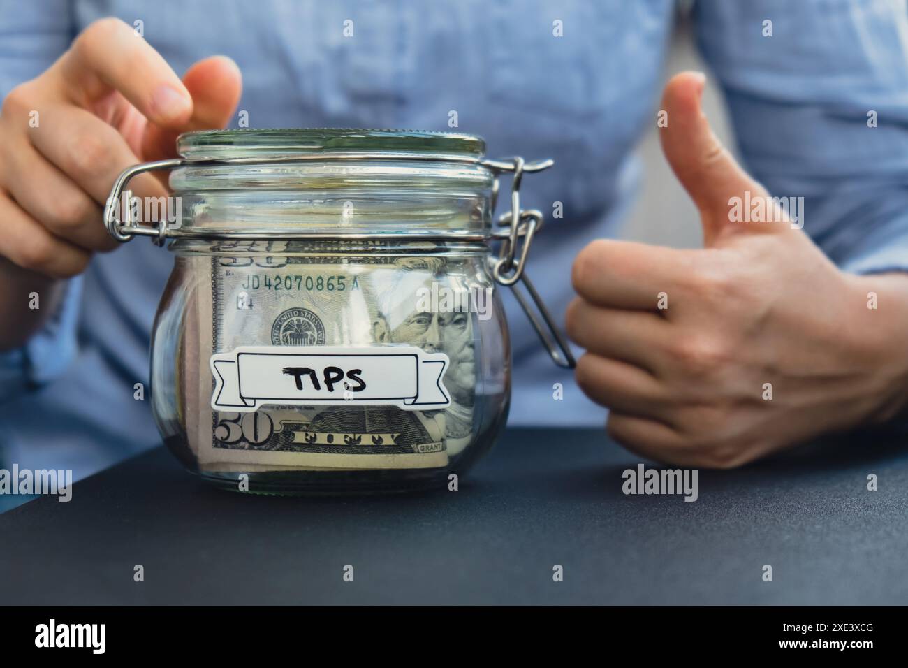 Unrecognizable woman holding Glass jar full of American currency ...