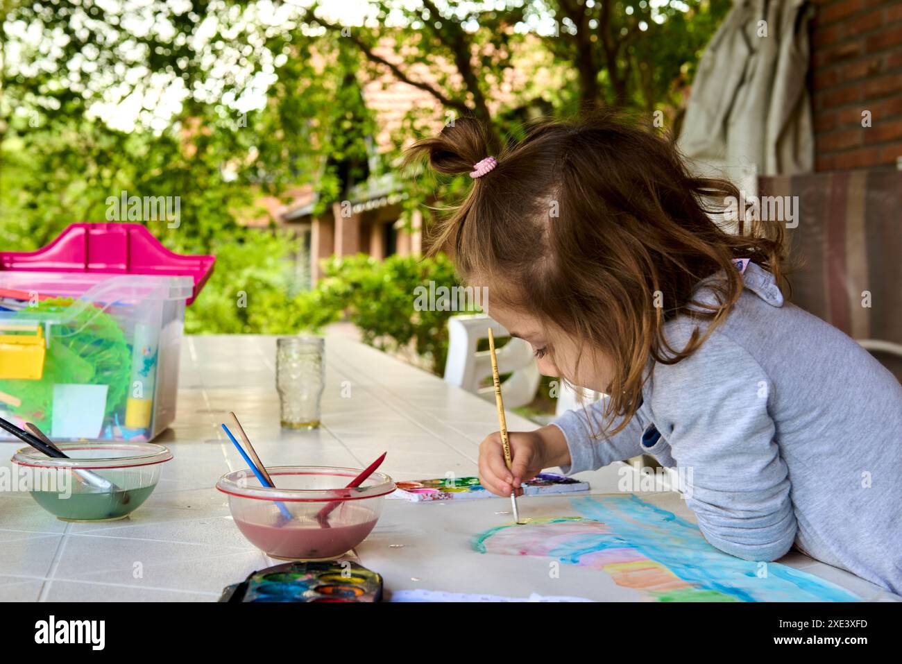 Side view photo of a very concentrated and focused girl drawing with ...