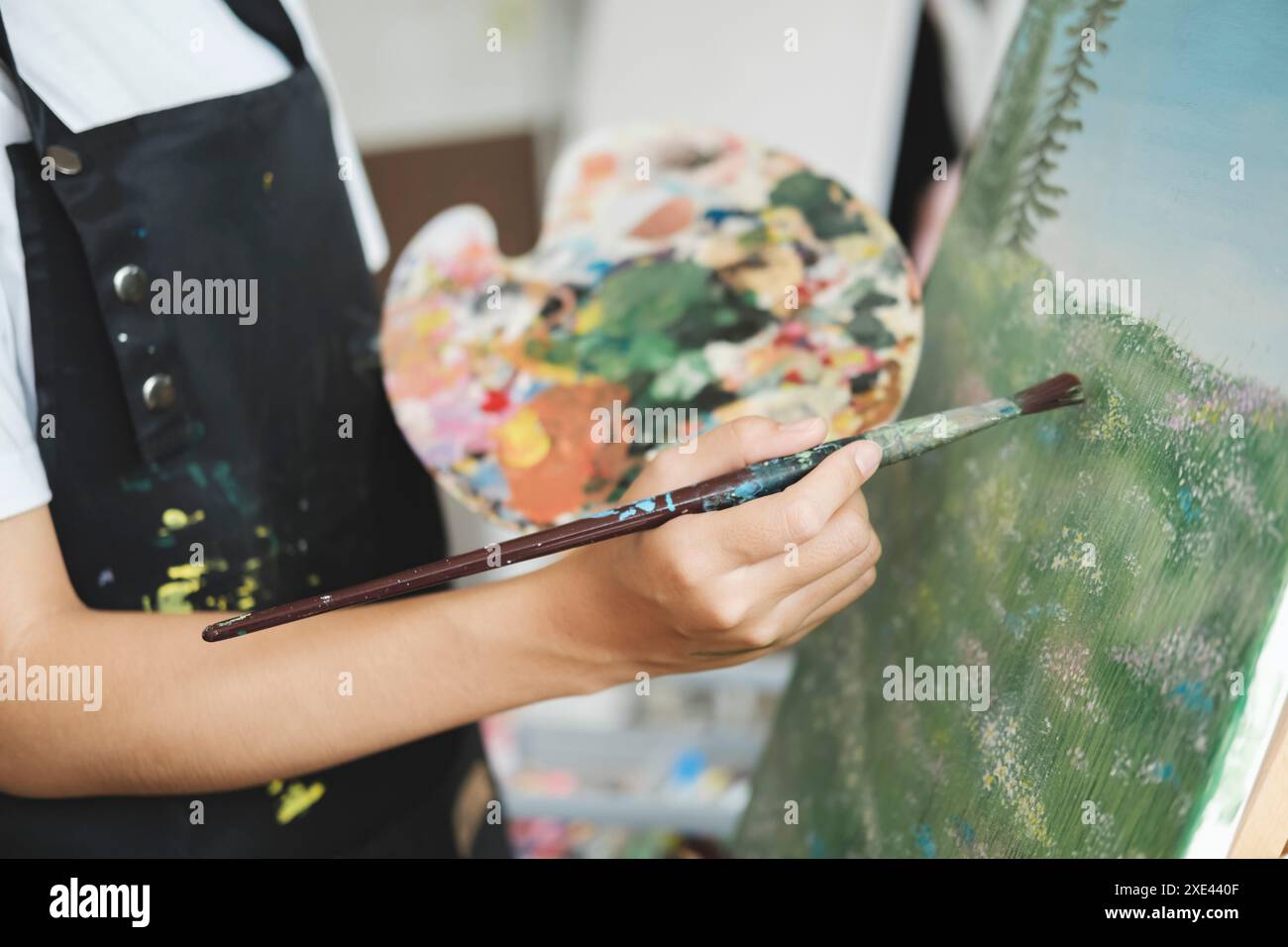 Young Asian female artist painting on canvas doing art projects on her ...