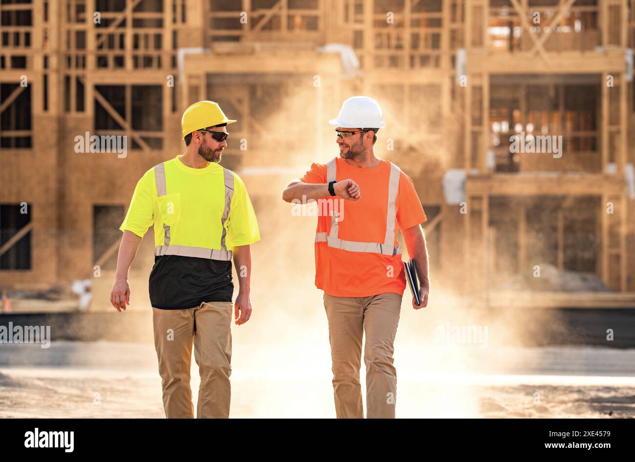 Two construction workers with hardhat helmet on construction site ...