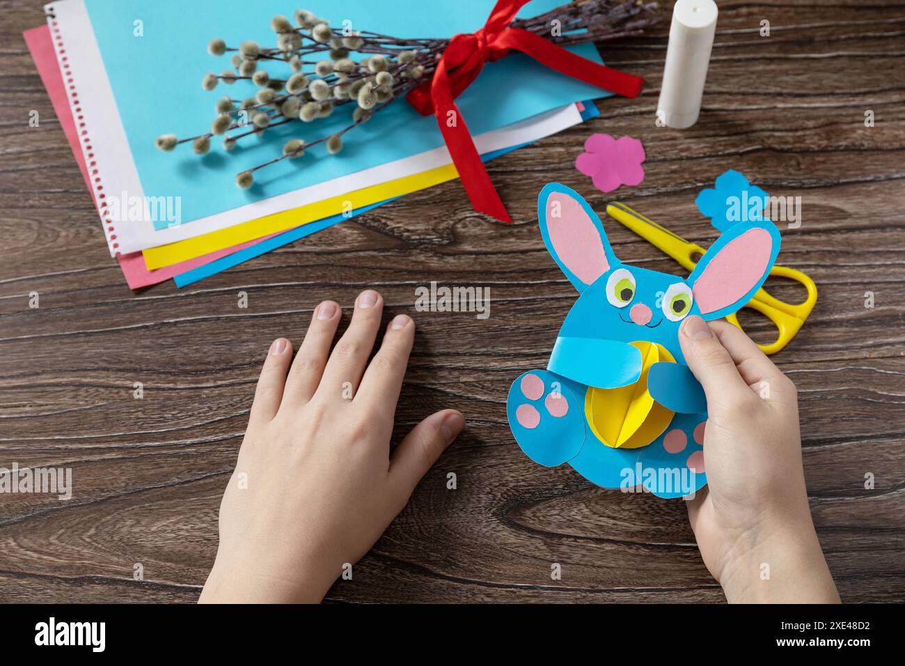 A child is holding an Easter bunny toy card with easter egg. Handmade ...