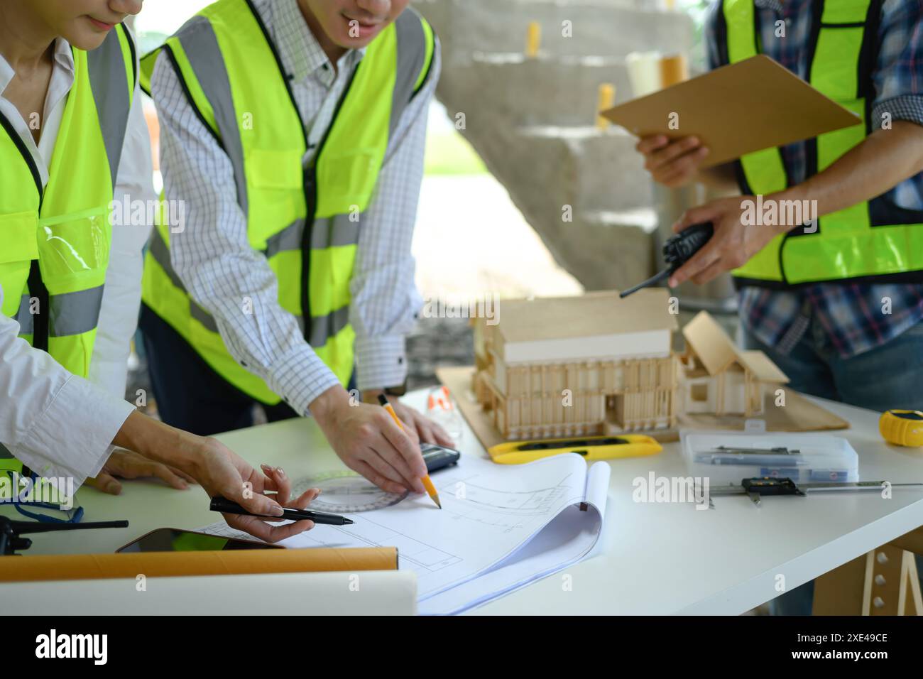 Engineer team having briefing about project reviewing blueprints at a ...