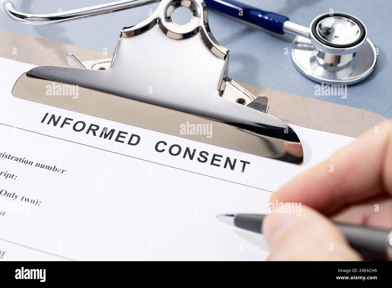 Hand filling a Informed Consent form on desk Stock Photo - Alamy