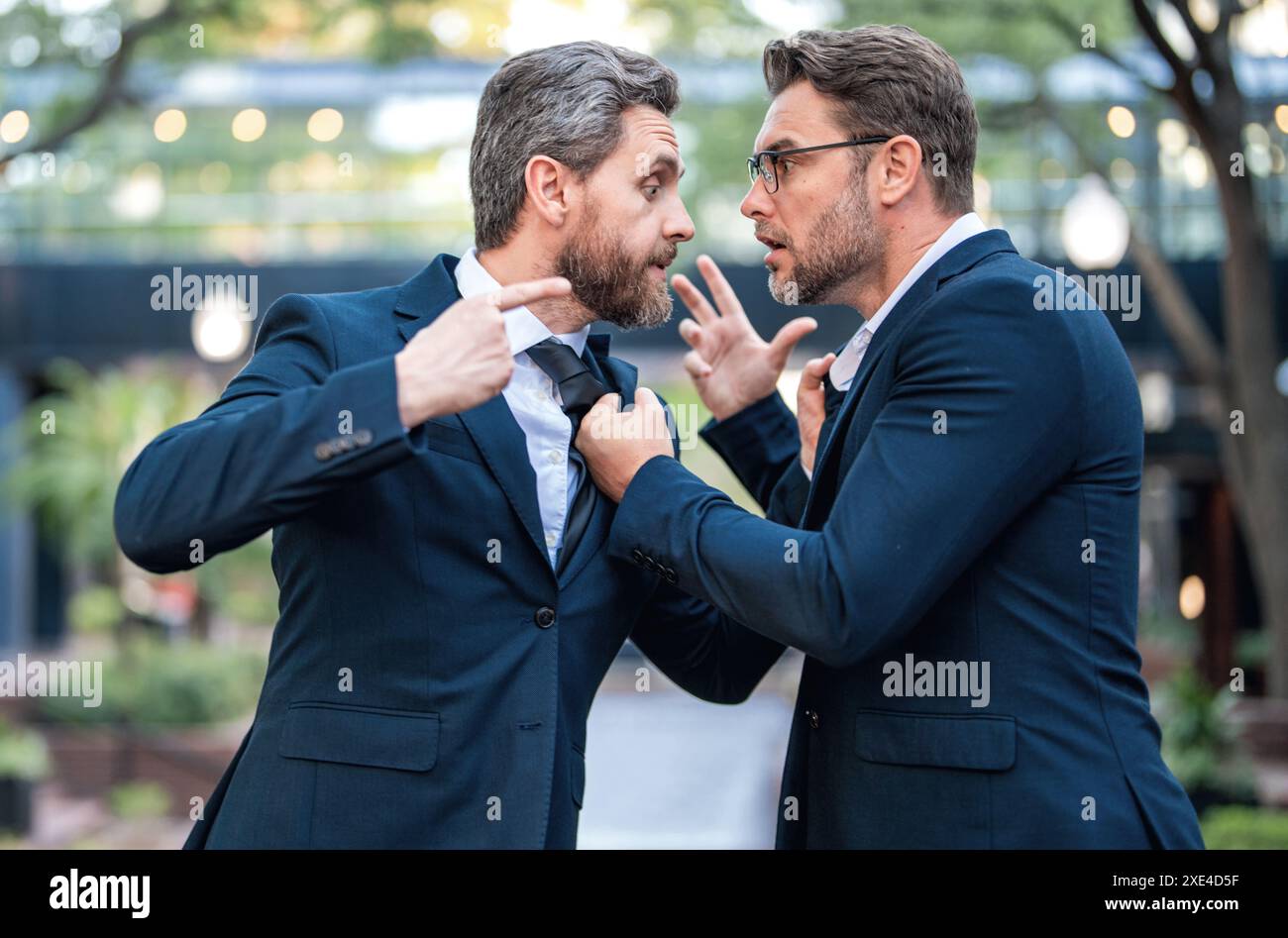 Businessmen fighting outdoor. Angry office workers in city. Disagreed ...