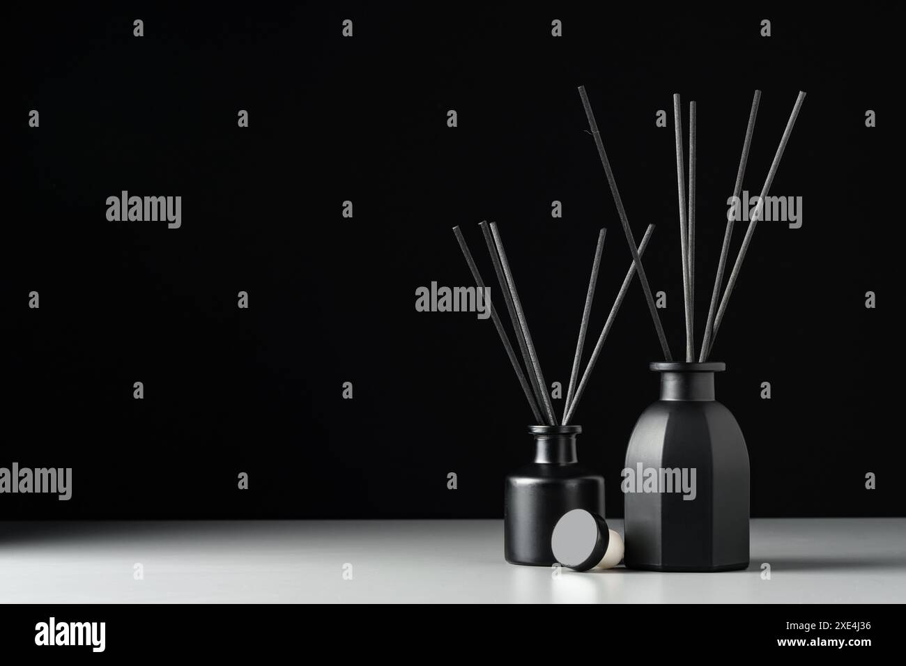 Two Black Reed Diffuser Bottles on White Surface Against Black ...