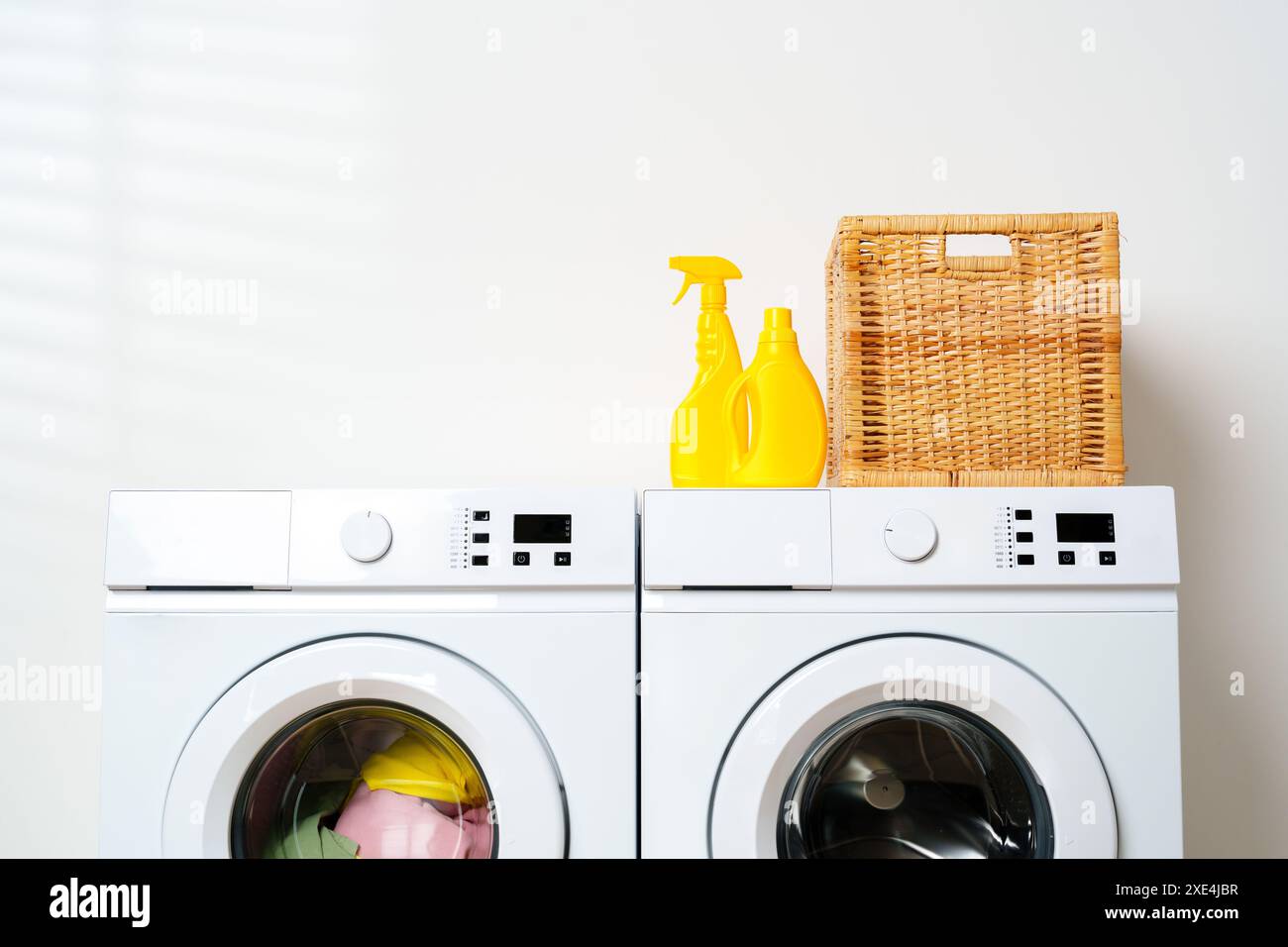 White Washing Machine With Yellow Cleaning Supplies in a Laundry Room ...