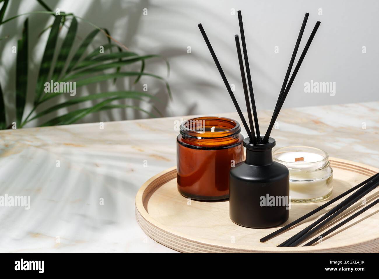 Black Reed Diffuser, Amber Candle, and Wooden Tray on White Surface ...
