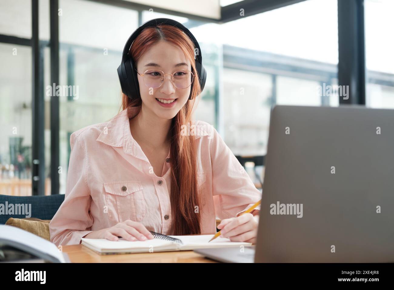 Young collage student using computer and mobile device studying online ...