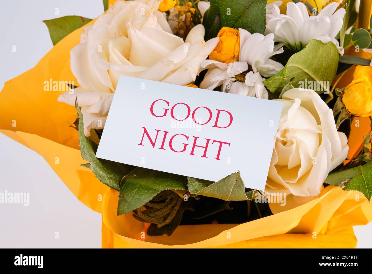 GOOD NIGHT word written on a card hidden in a bouquet of beautiful ...