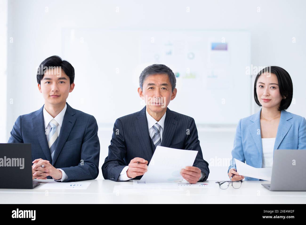 Three men and a woman interviewing in an office Stock Photo - Alamy