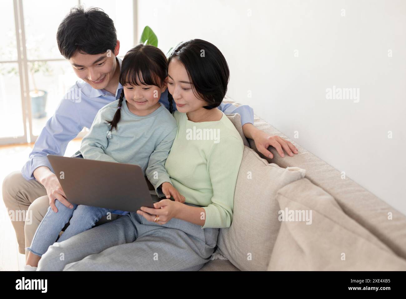 Family looking at computer Stock Photo - Alamy