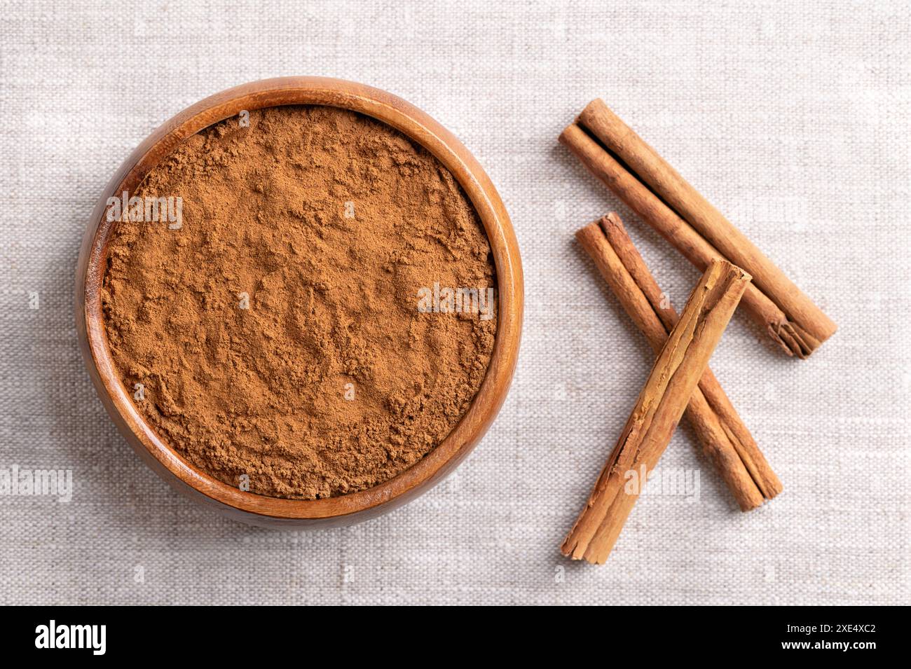 Ceylon cinnamon powder in a wooden bowl on linen. Ground bark of Ceylon ...
