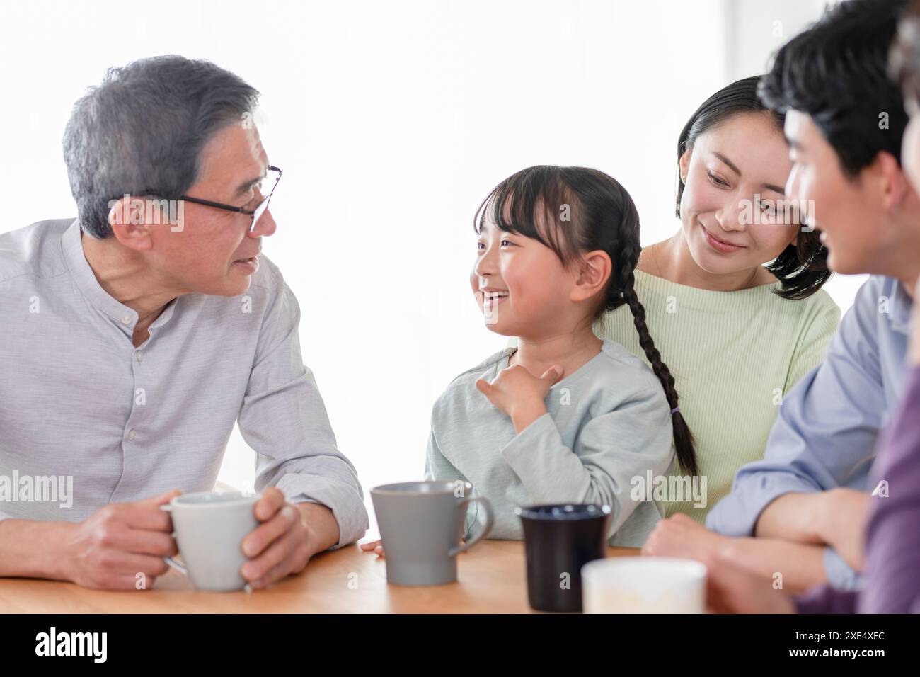 Family of three generations enjoying a meal in the living room Stock ...