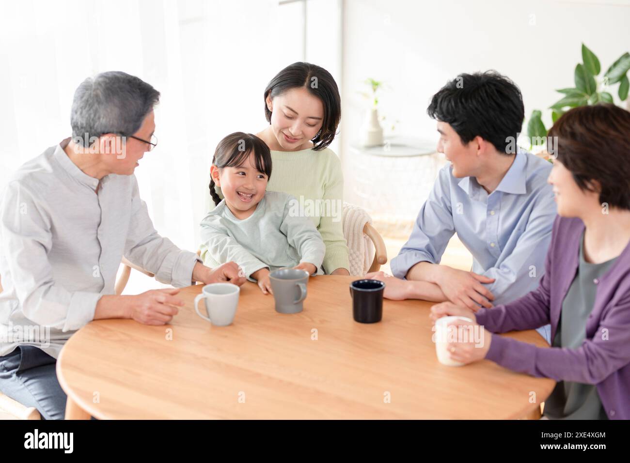 Family of three generations enjoying a meal in the living room Stock ...