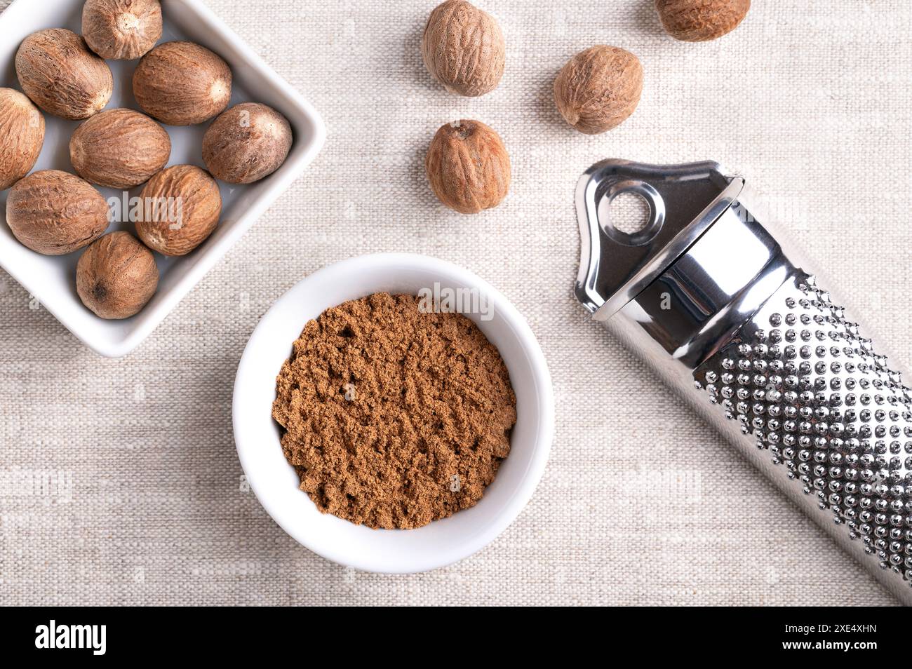 Nutmeg powder, ground nutmeg in a small white bowl on linen fabric ...
