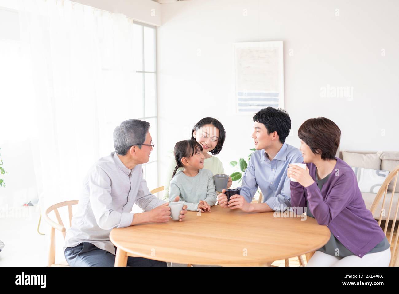 Family of three generations enjoying a meal in the living room Stock ...