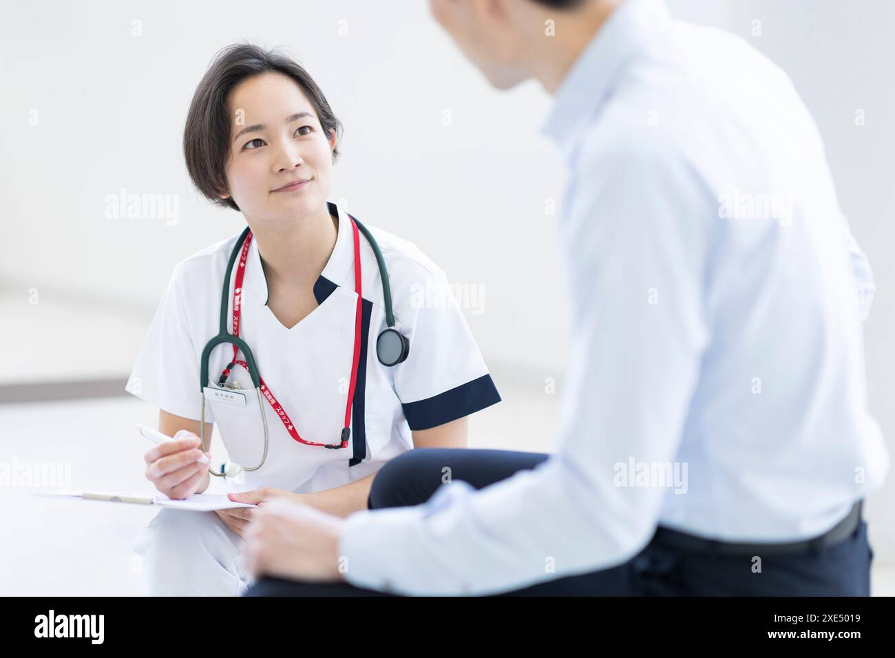 Nurse listening to patient Stock Photo - Alamy