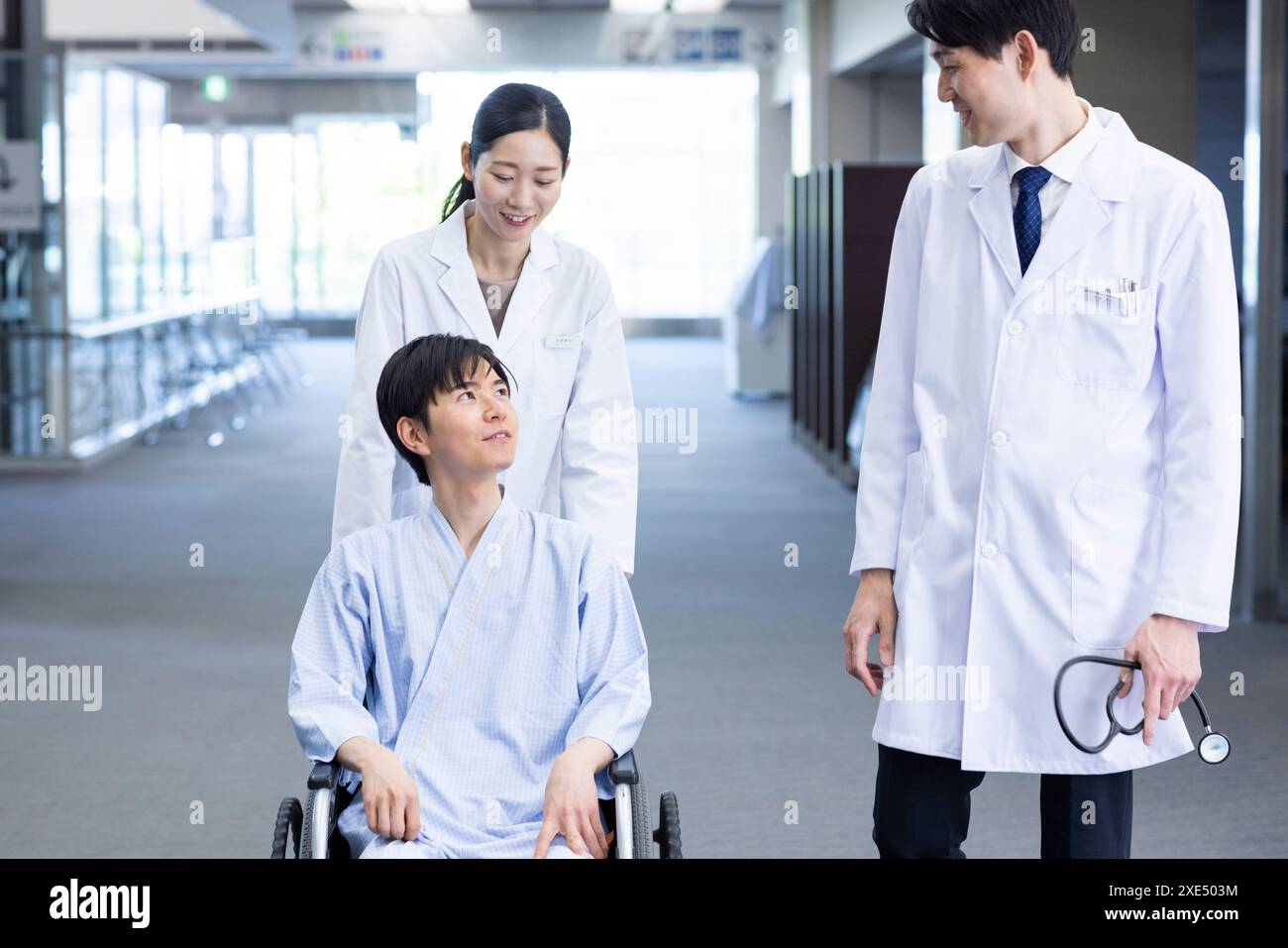 Doctor pushing wheelchair Stock Photo - Alamy