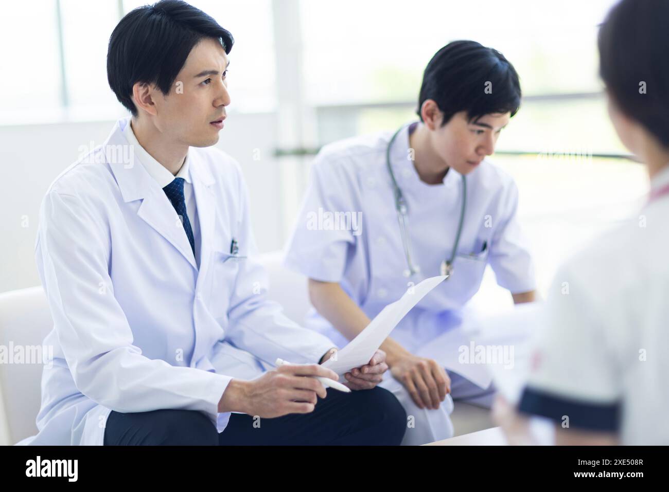 Serious male doctor sitting hi-res stock photography and images - Alamy