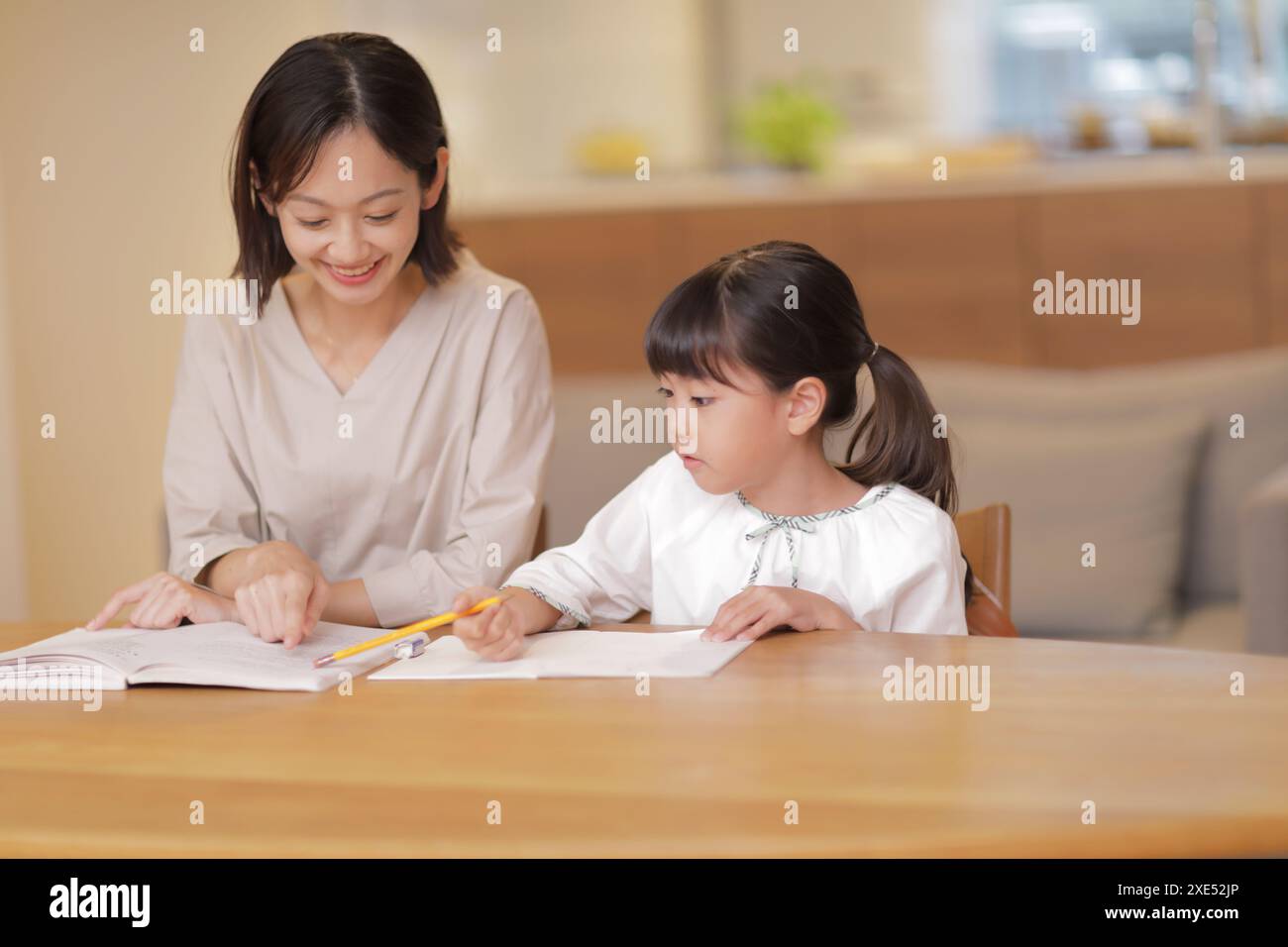 Mother teaching her daughter to study Stock Photo - Alamy