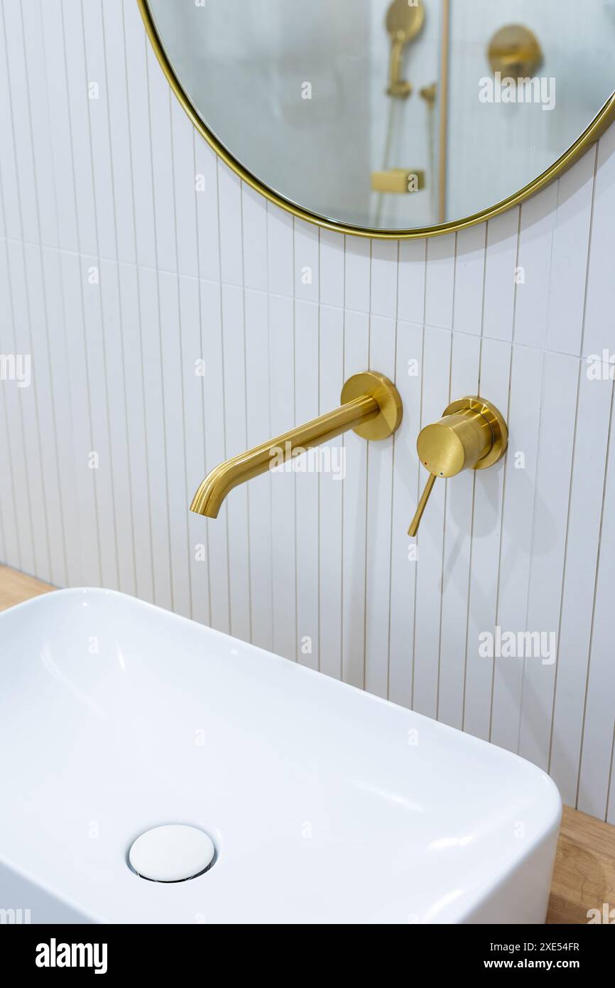 Bronze bathroom water tap in a bathroom finished with white tiles ...