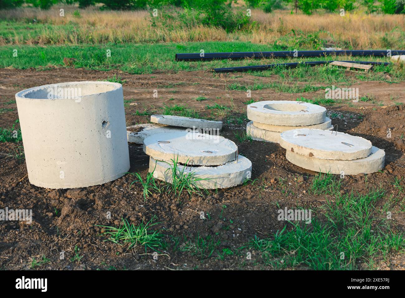 Cement blocks and a cement pipe are on the ground. Stone blocks are ...