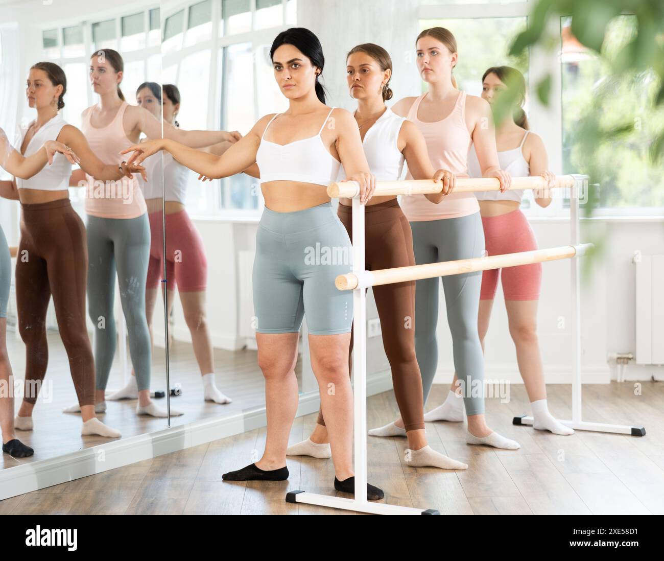 Group of positive young girls standing in row together while doing ...