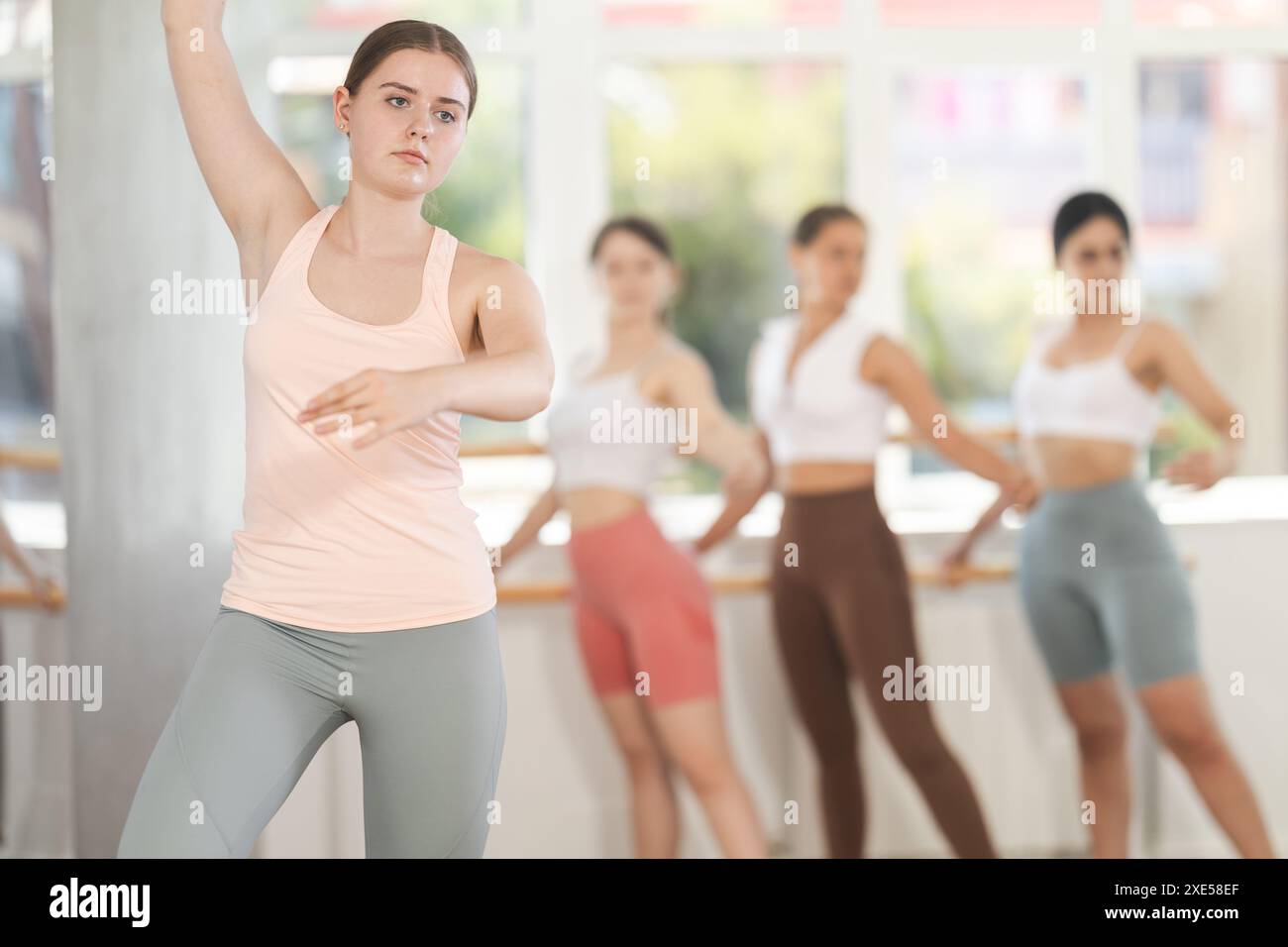 Warm-up sessions. Cheerful fit active young girl training various ...