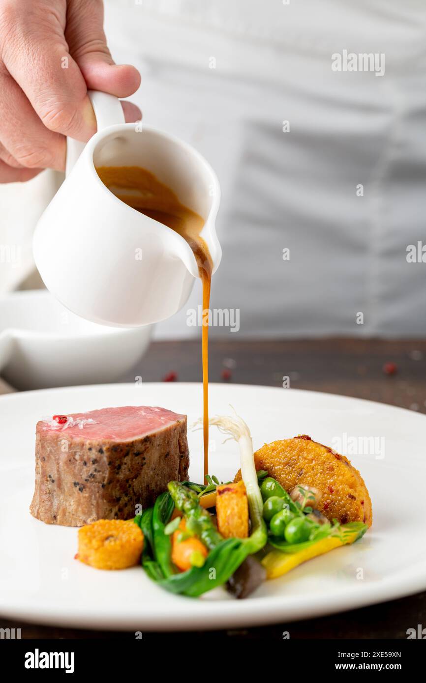 Filet mignon served with vegetables and sauces at a fine dining ...