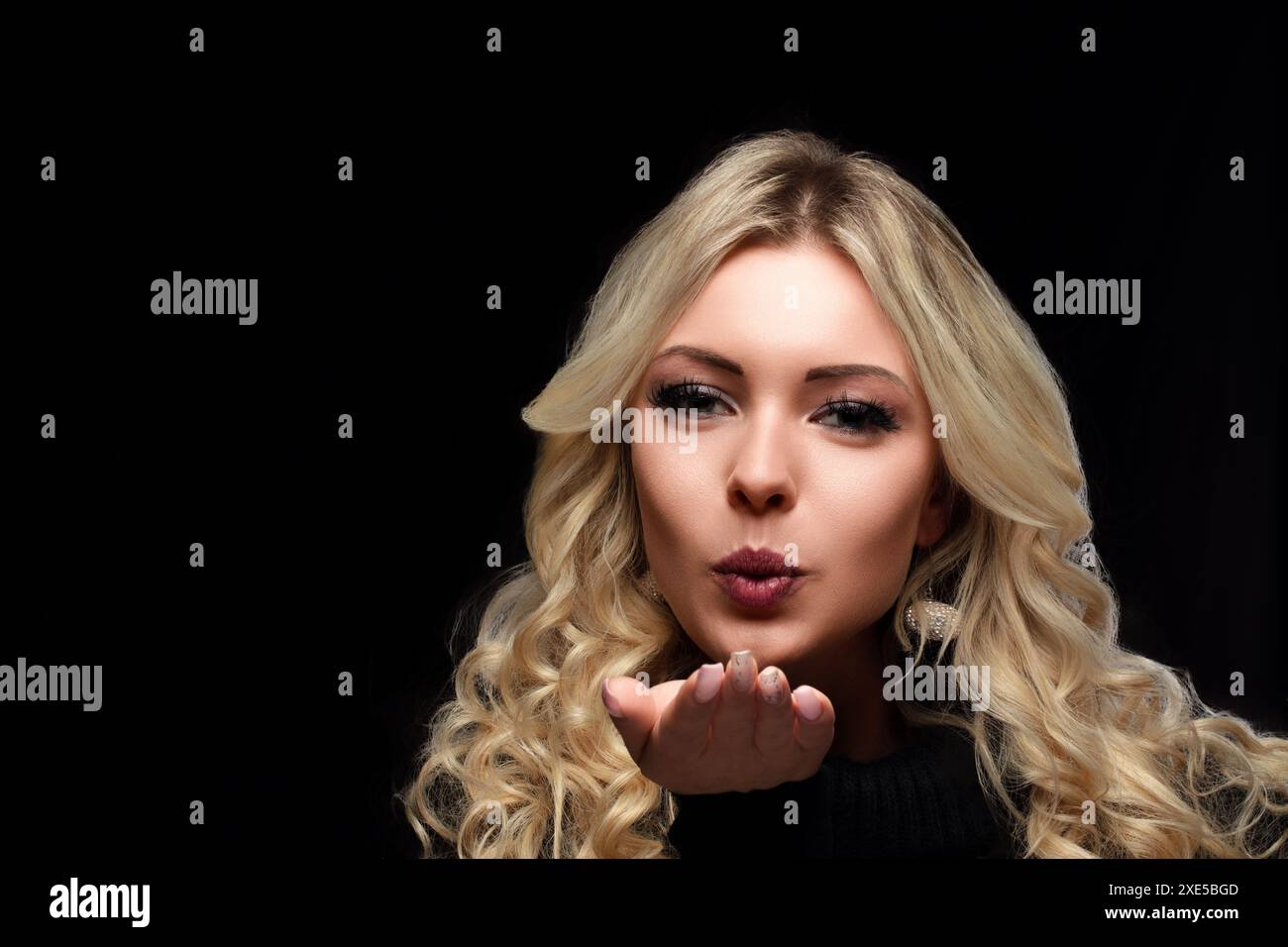 Blonde woman with blue eyes, curly hair, and black turtleneck sweater ...