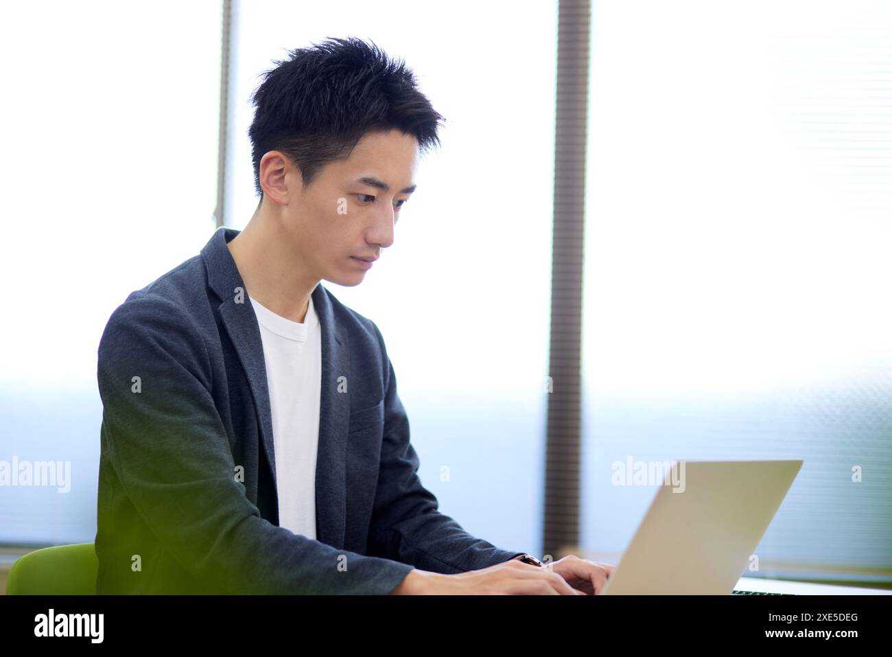 Young Japanese businessmen operating a computer in the rain Stock Photo ...