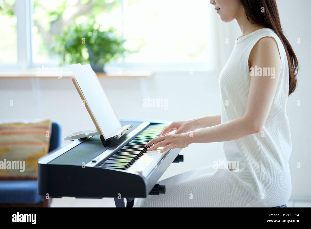 Japanese woman playing the piano in the living room Stock Photo - Alamy