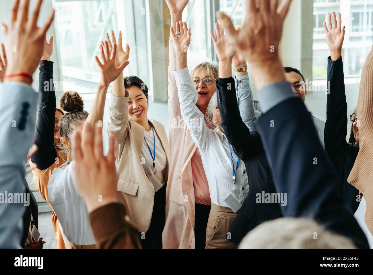Happy and positive business team raising hands and celebrating success ...