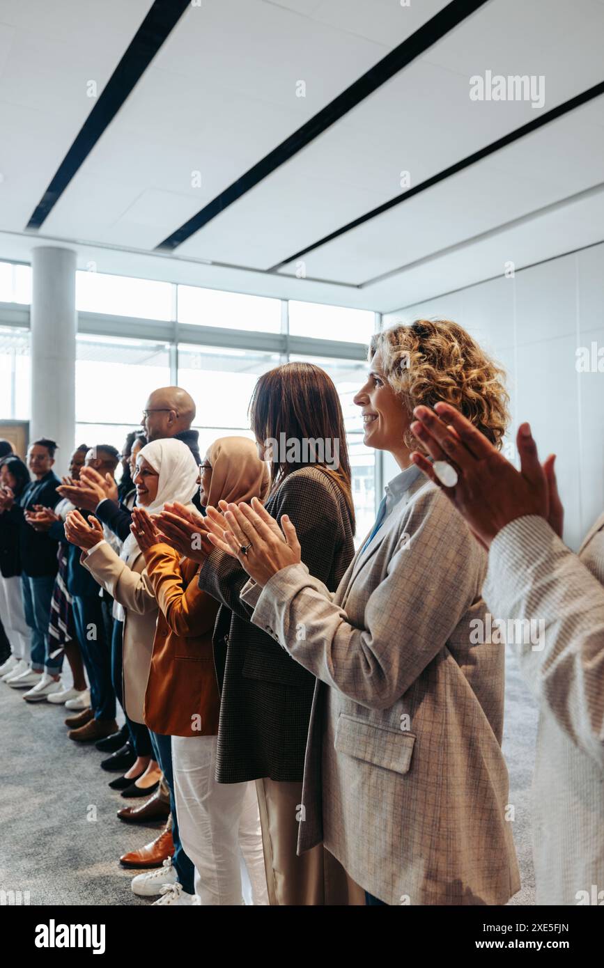Successful and diverse team applauding during a workshop in a modern ...