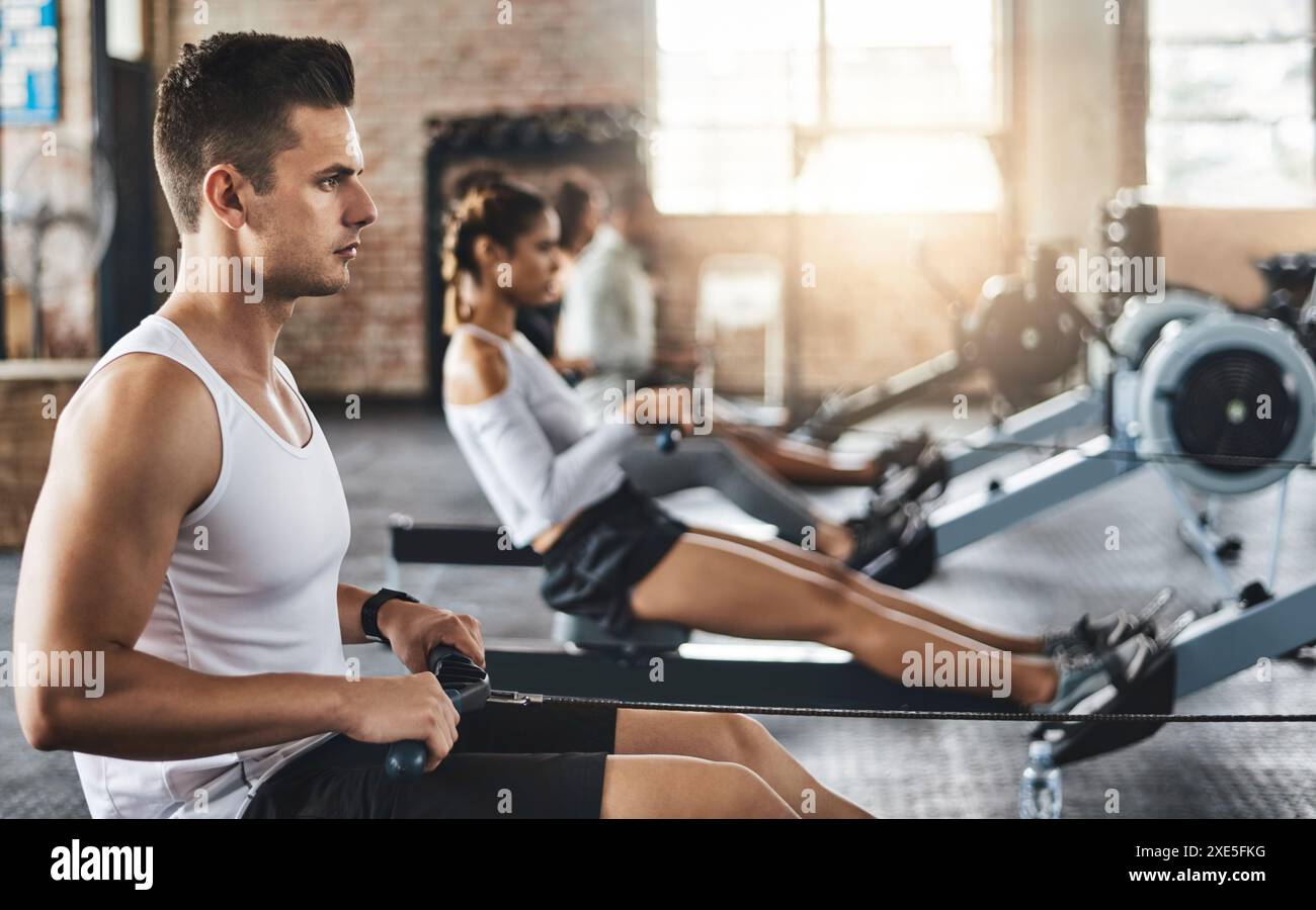 Sports, gym and man on rowing machine for health, wellness and body ...