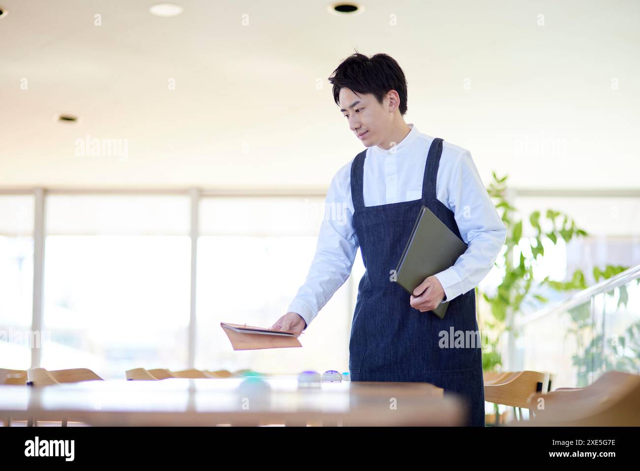 Young Japanese man working in café Stock Photo - Alamy