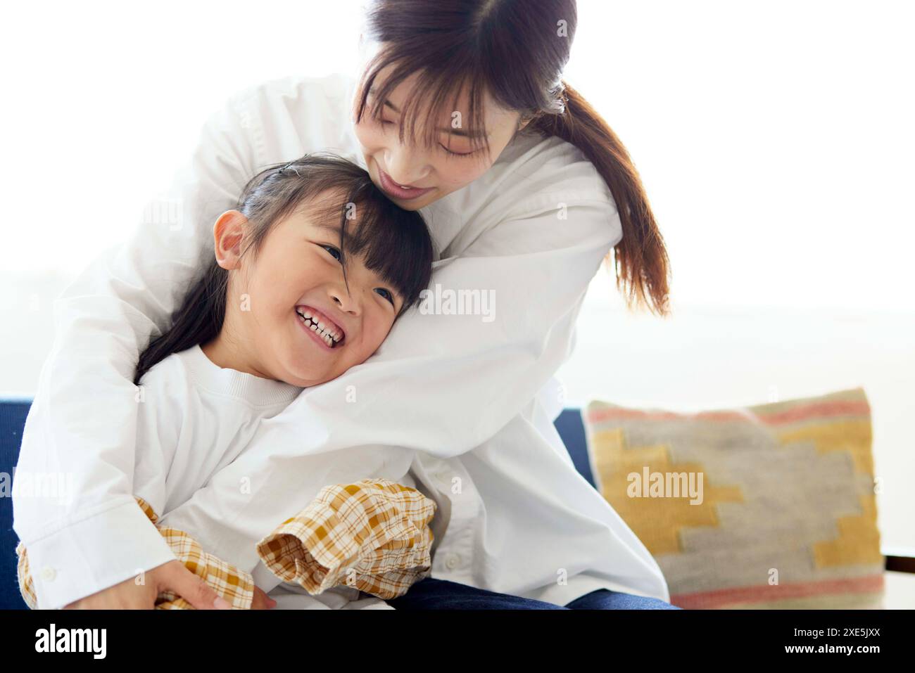 Happy Japanese playing cheerfully on the sofa Stock Photo - Alamy