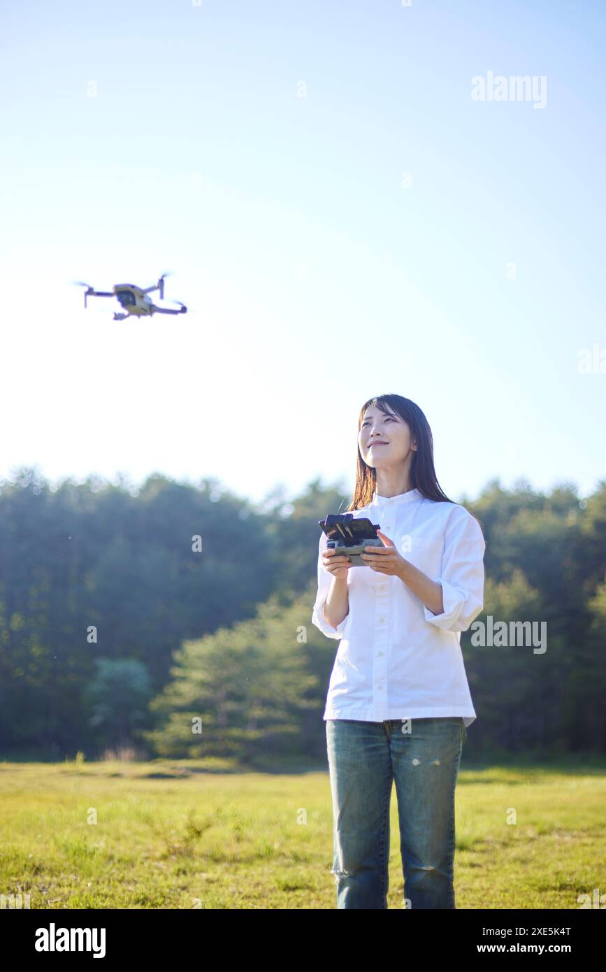Asian female flying a drone hi-res stock photography and images - Alamy