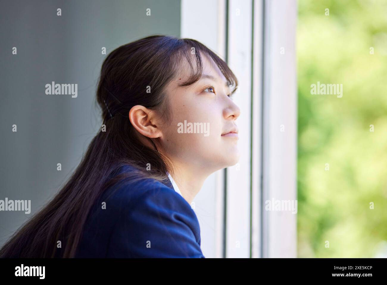 High school girl looking out of window Stock Photo - Alamy